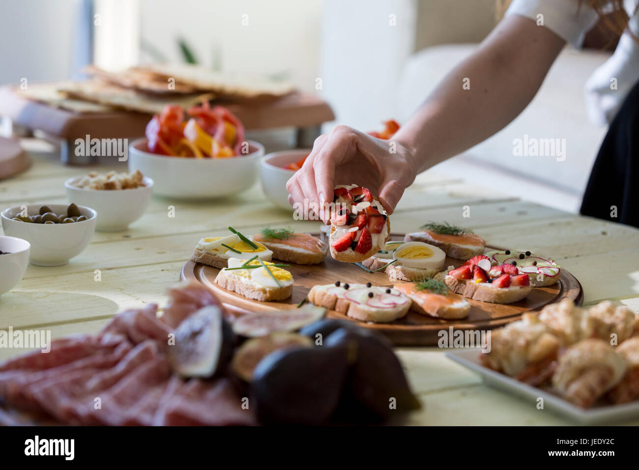 Hand reaching for appetizers on table Stock Photo - Alamy