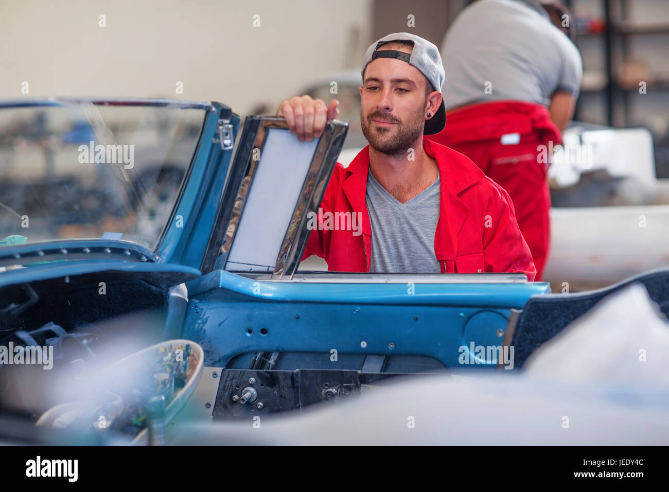 Mechanics restoring vintage cars in workshop Stock Photo - Alamy