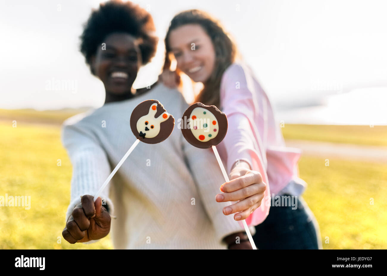 Two happy friends holding Easter chocolates Stock Photo - Alamy