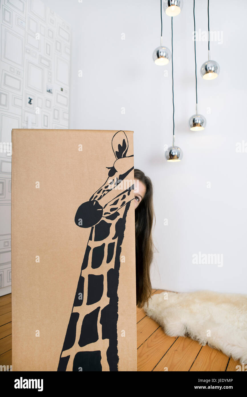Girl inside a cardboard box painted with a giraffe Stock Photo - Alamy