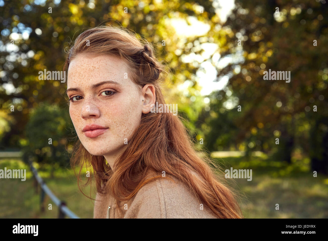 Portrait of redheaded young woman with freckles in a park Stock Photo ...