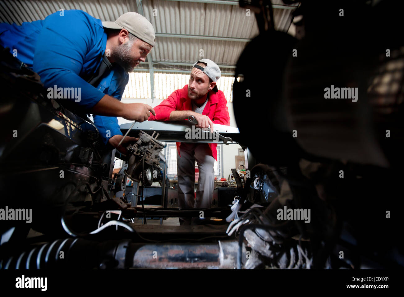 Mechanics in garage workshop discussing hi-res stock photography and ...