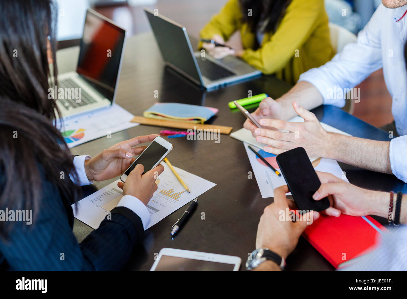 Business people using cell phones during a meeting in office Stock ...