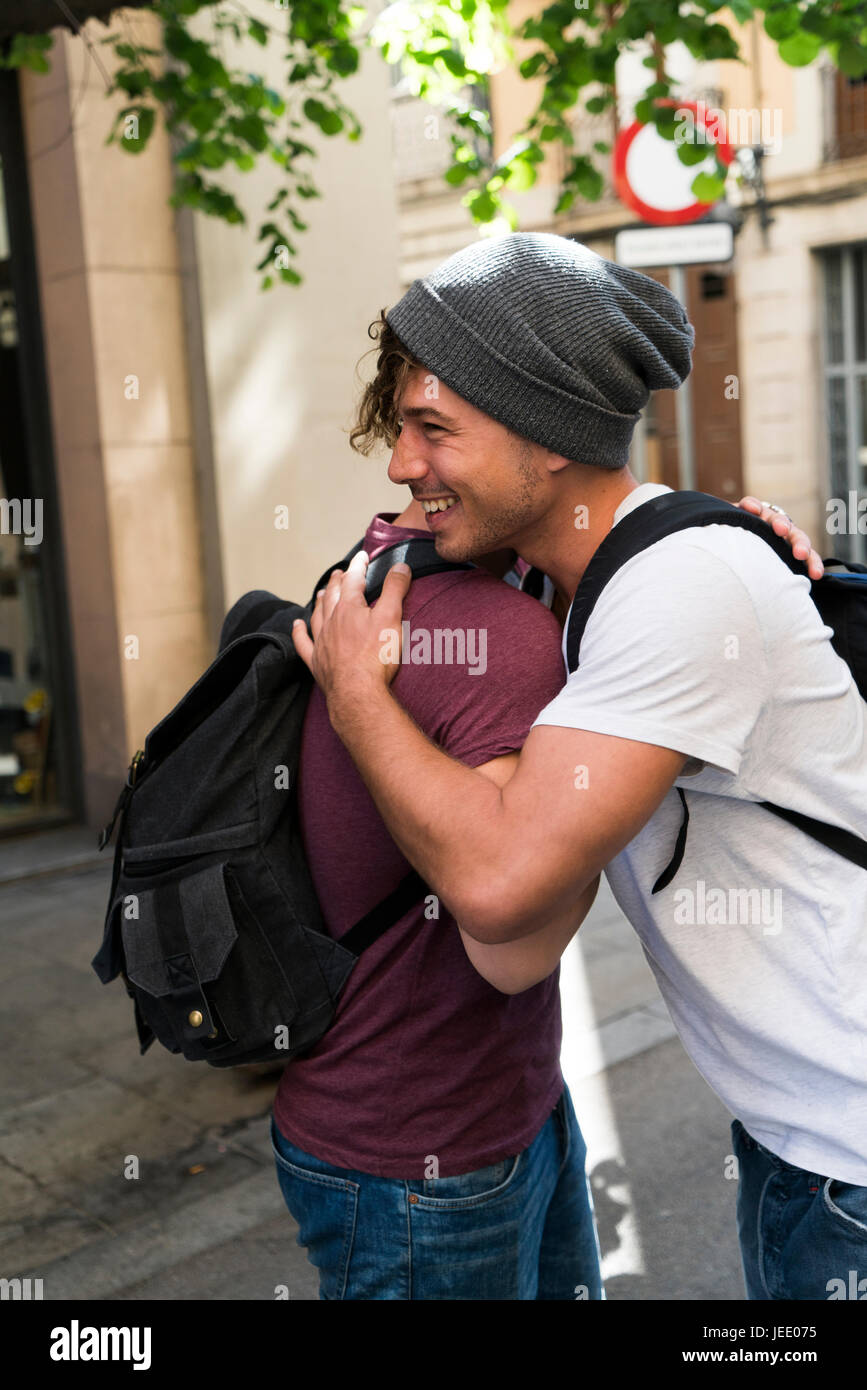 Two young men embracing in the city Stock Photo - Alamy