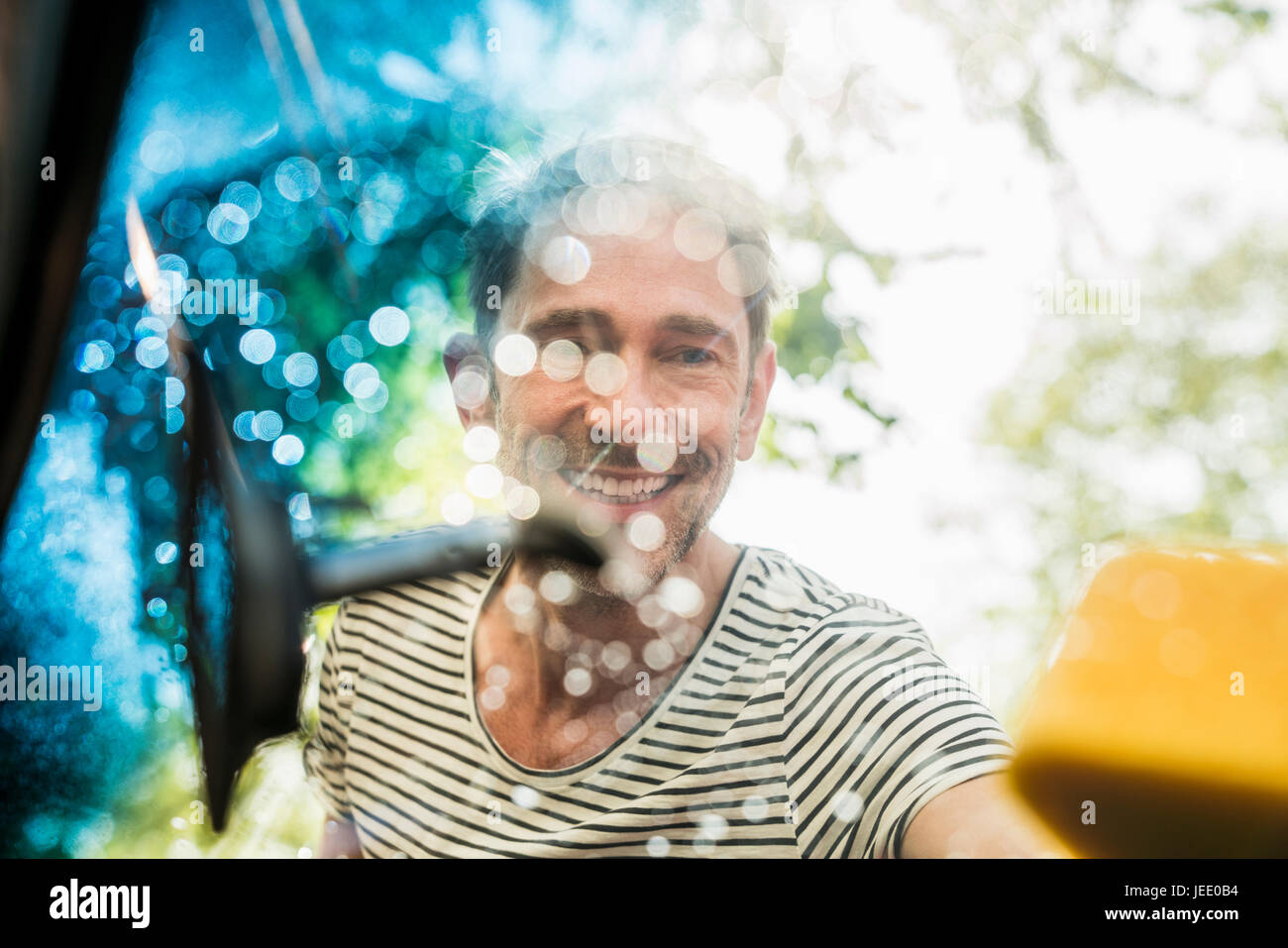 Portrait of smiling mature man washing windscreen of his car Stock ...