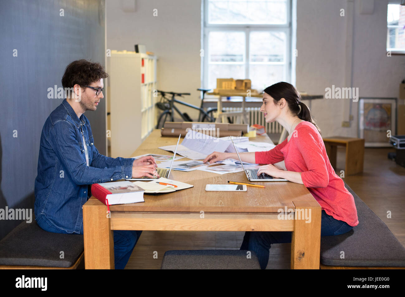 Man and woman working on project in office together Stock Photo - Alamy