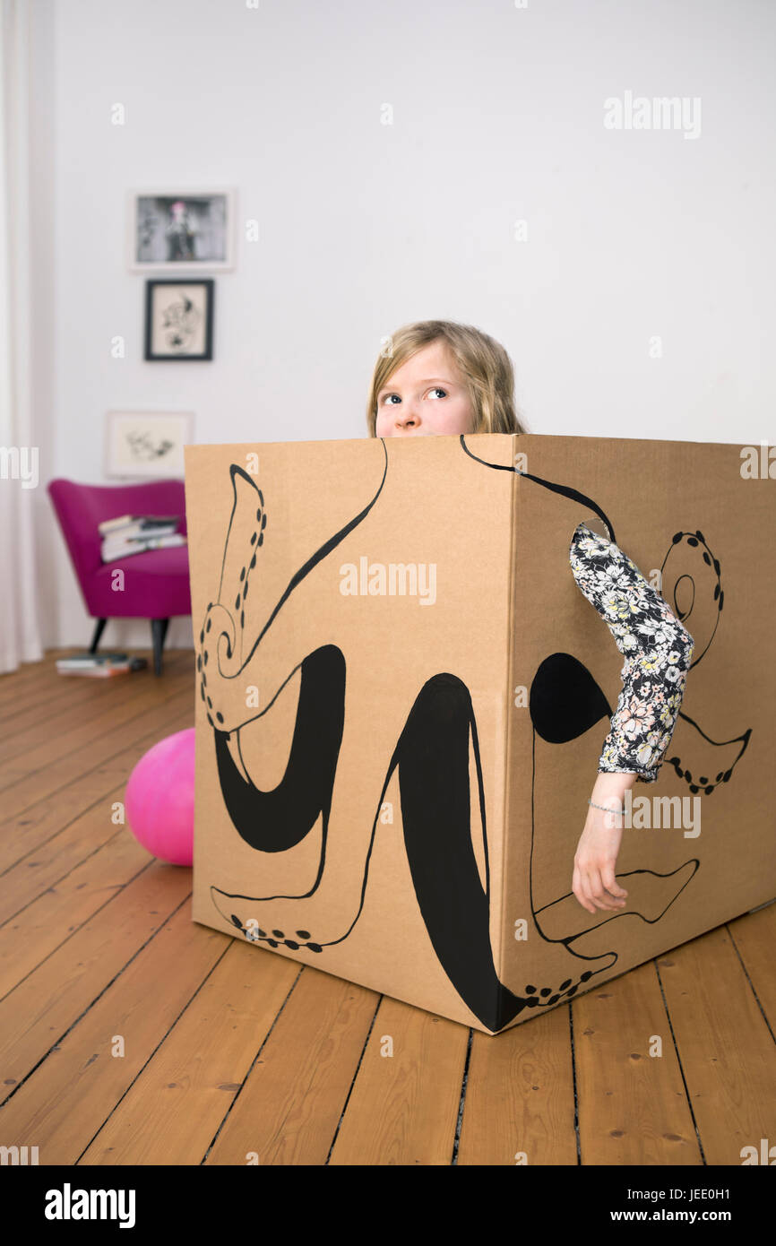Girl inside a cardboard box painted with an octopus Stock Photo - Alamy