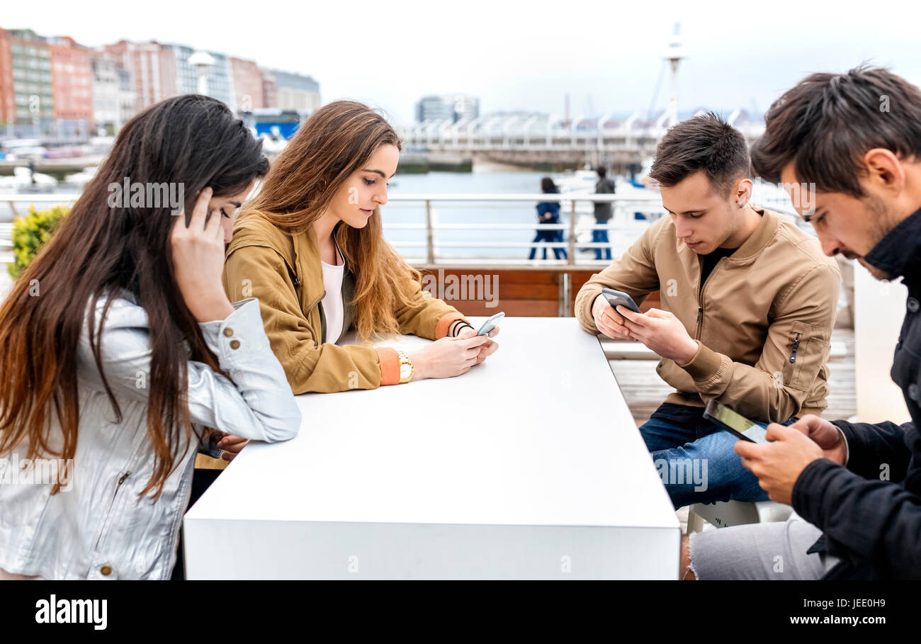 Group of friends using their smartphones Stock Photo - Alamy