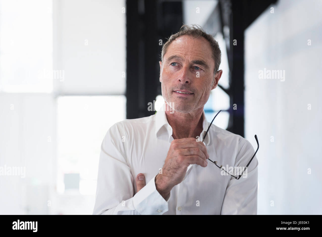 Man in factory thinking Stock Photo - Alamy