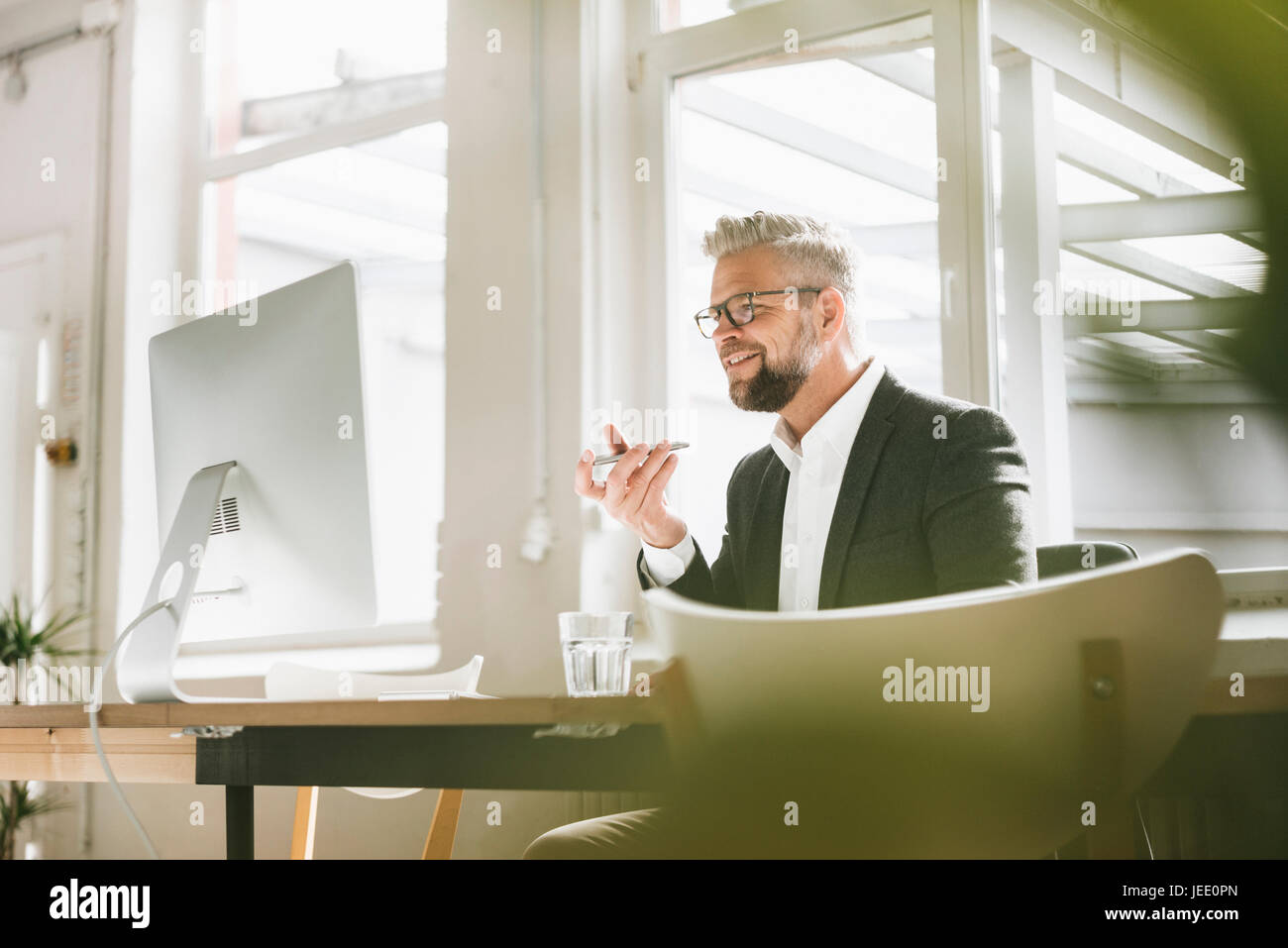 Businessman working in office using computer Stock Photo - Alamy