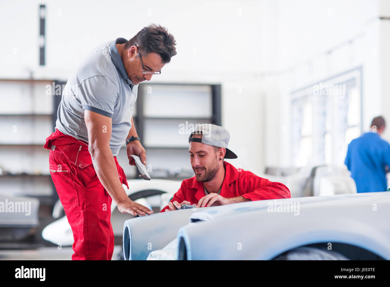 Mechanics restoring vintage cars in workshop Stock Photo - Alamy