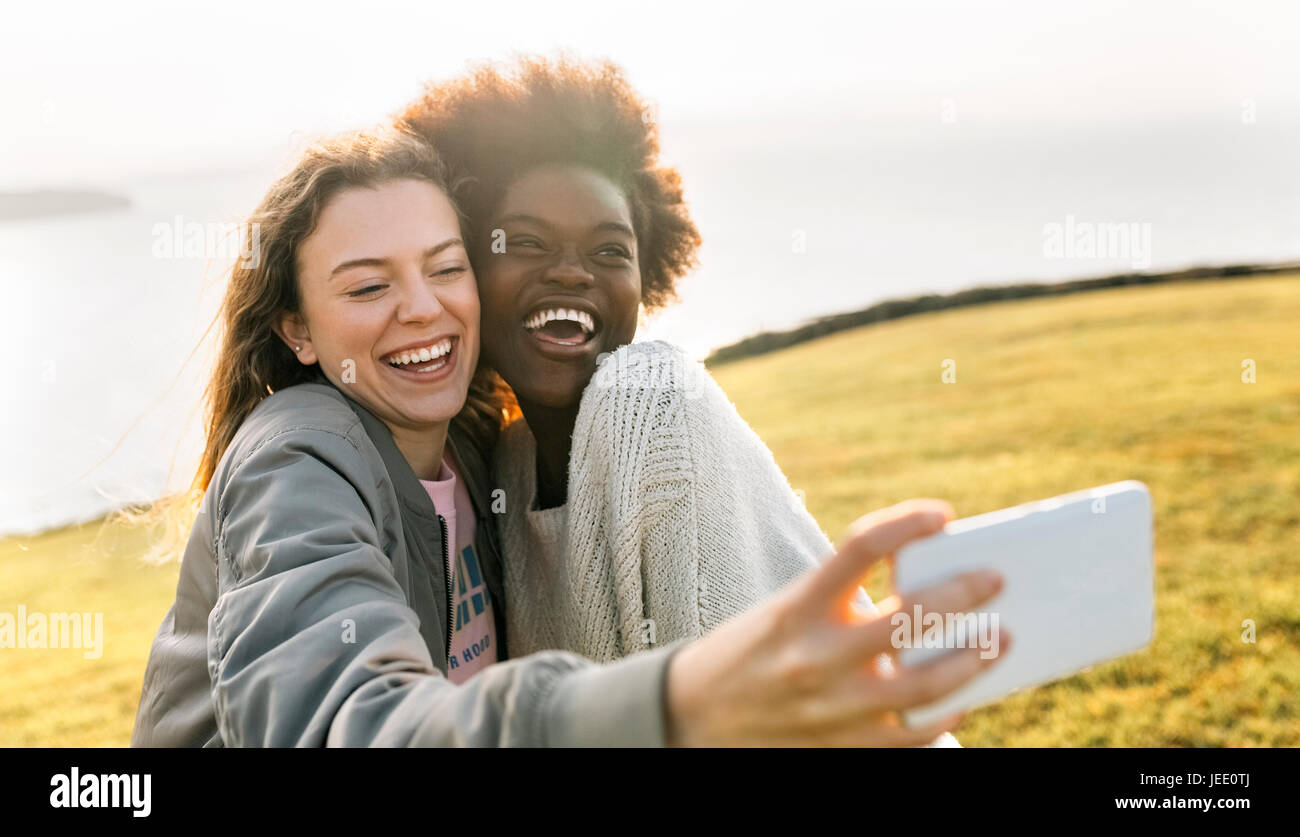 Two happy best friends making a selfie at the coast Stock Photo - Alamy
