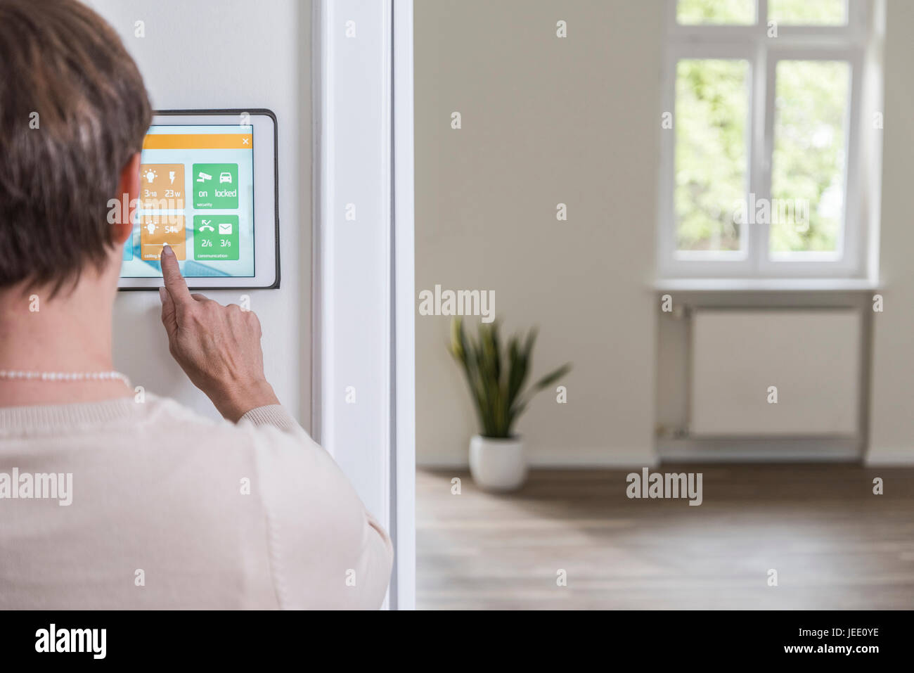 Woman using smart home screen Stock Photo - Alamy