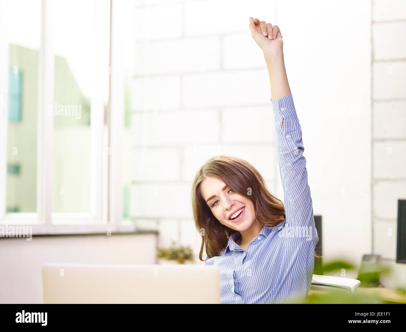 young caucasian business woman raising arm celebrating achievement and ...