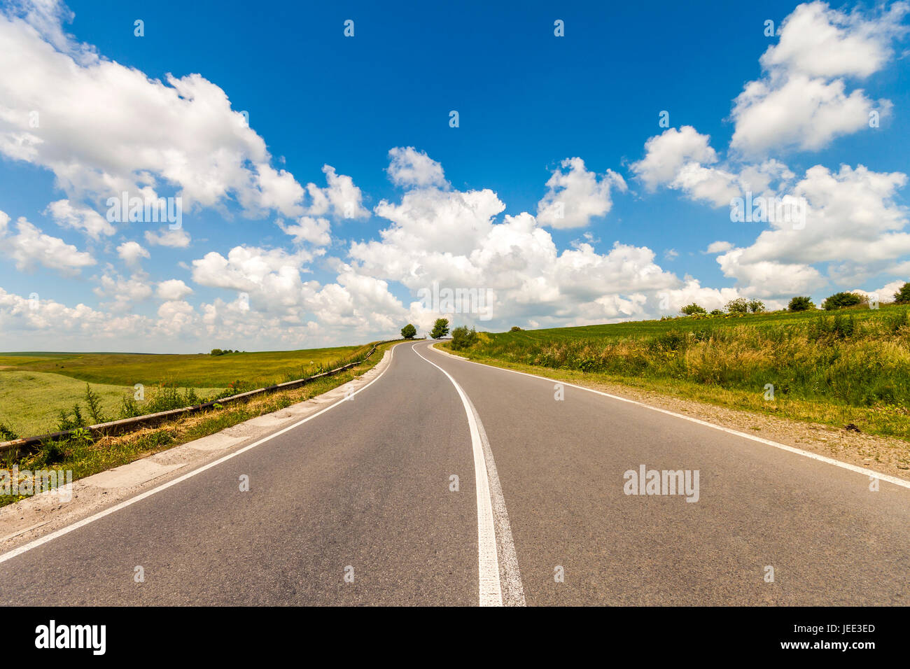 Summer asphalt road. Beautiful yellow road between fields landscape ...