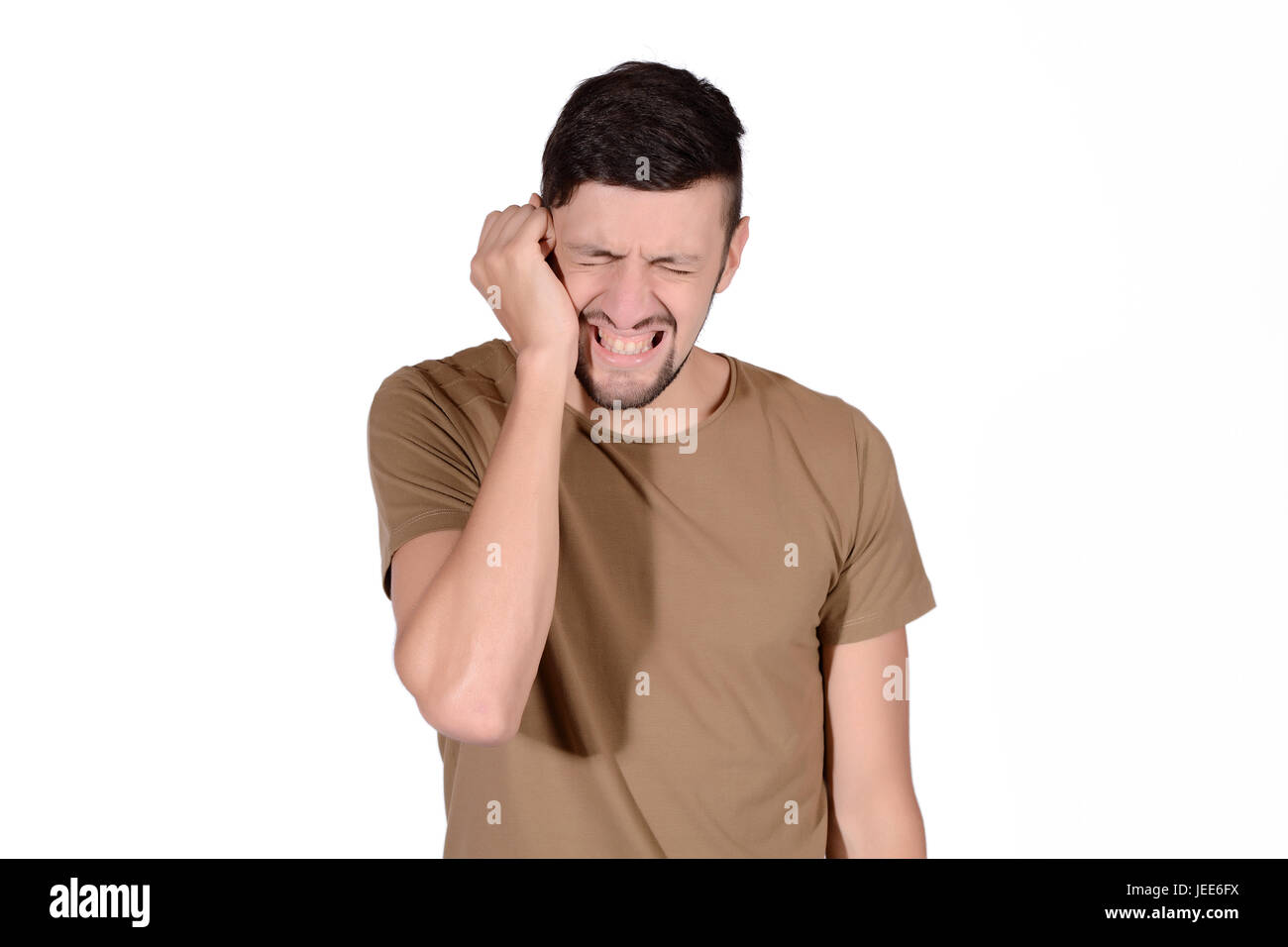 Portrait of a young man covering his ears. Isolated white background ...