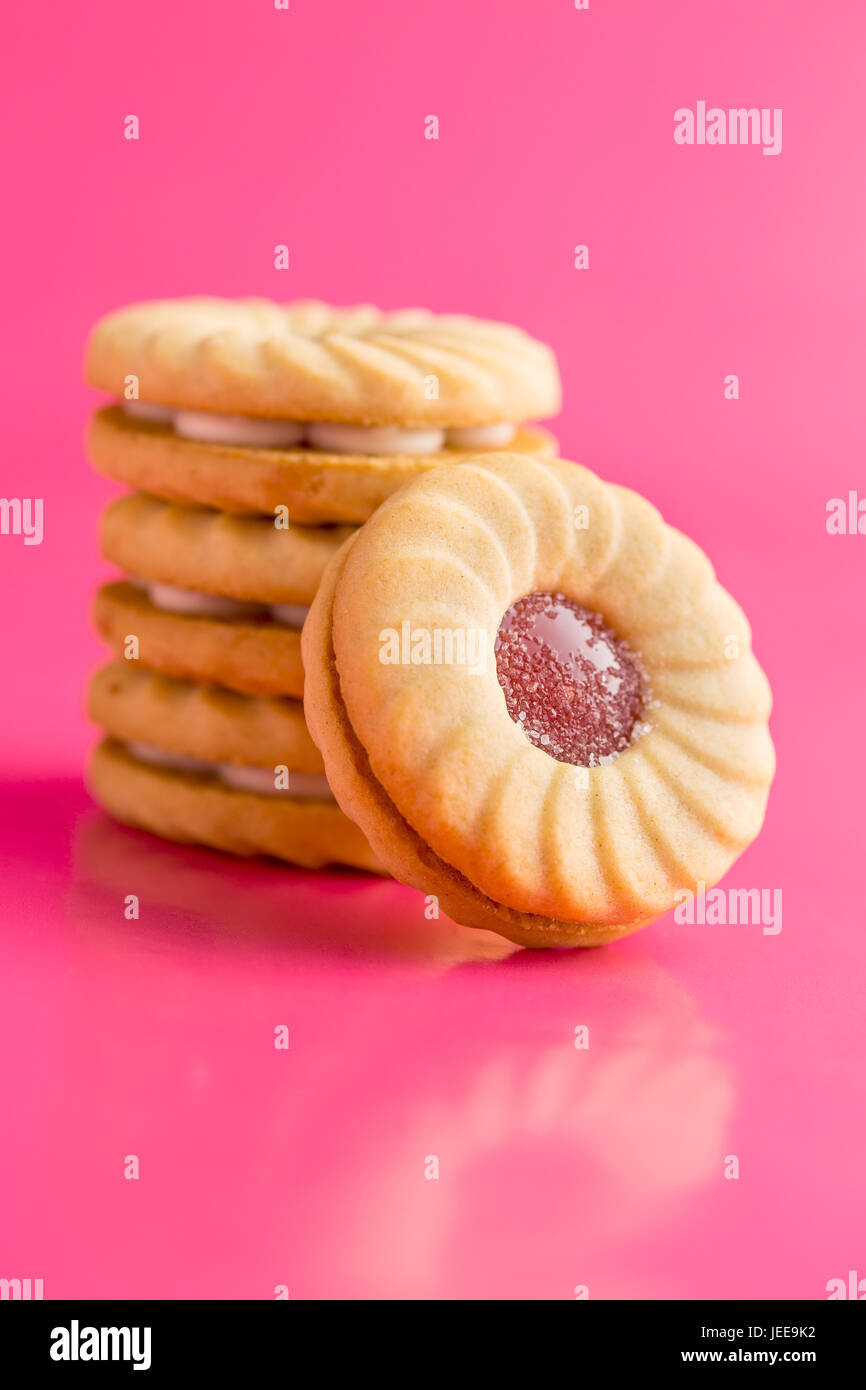 Sweet biscuits with jam on pink background Stock Photo - Alamy