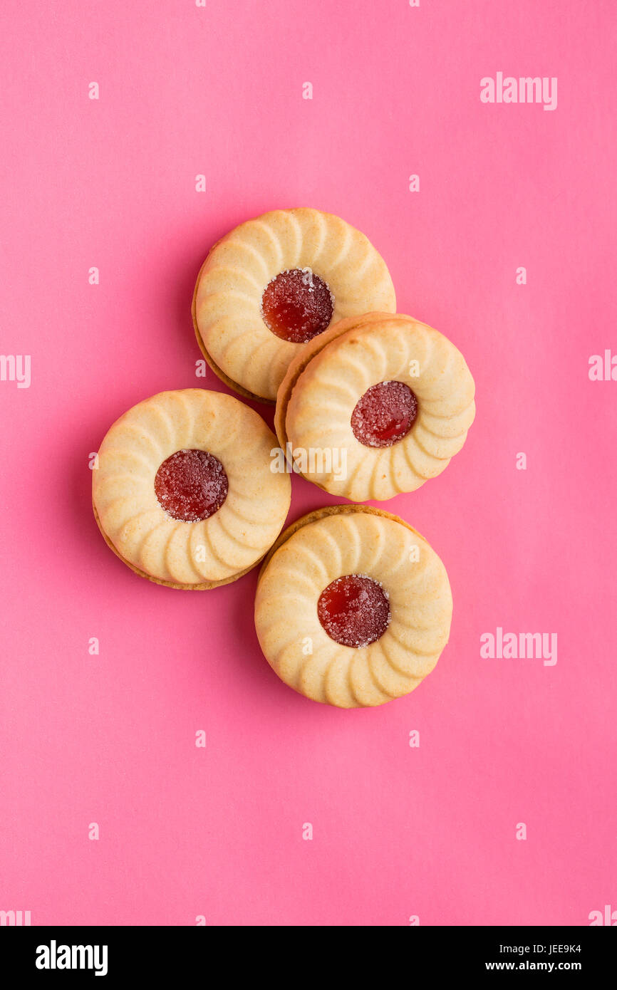 Sweet biscuits with jam on pink background Stock Photo - Alamy