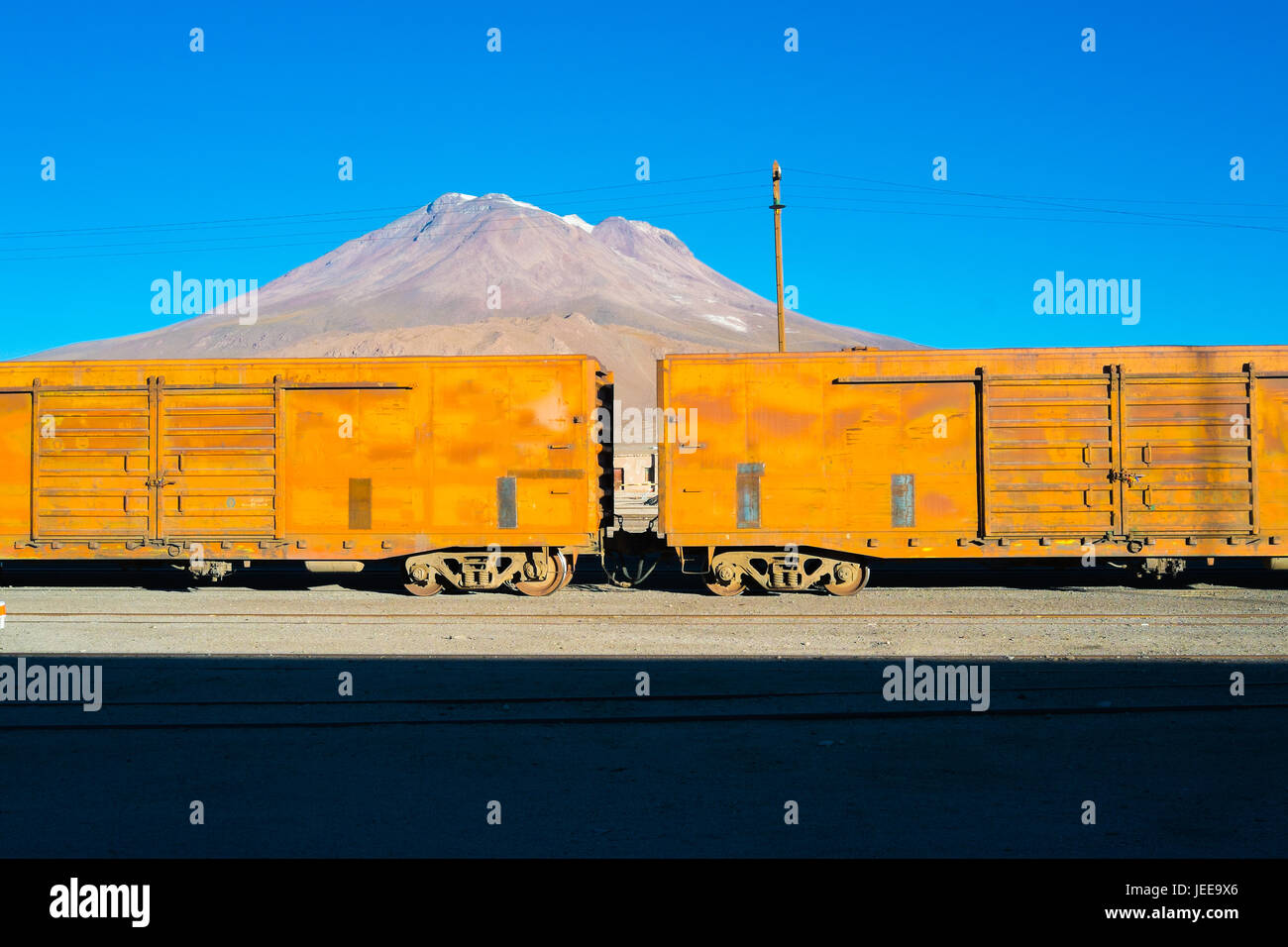 Cargo train and volcano in ollague station on the border between Chile ...