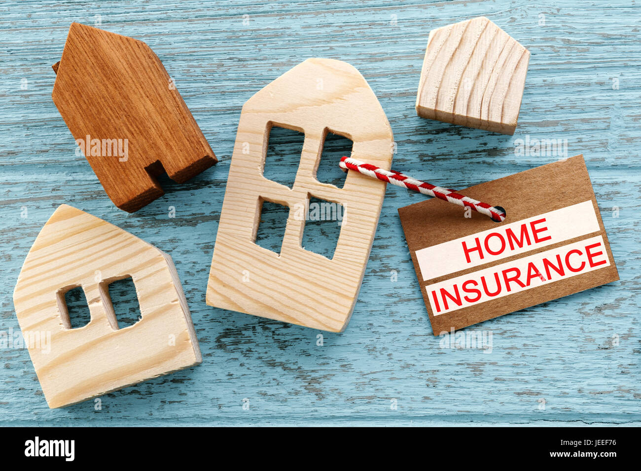 Home insurance concept with wood houses and paper insurance tag Stock ...