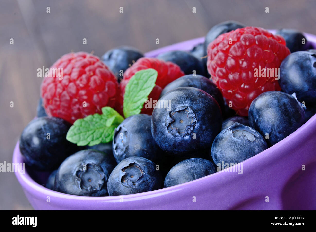 Blueberry and raspberry in a ceramic bowl on table Stock Photo - Alamy