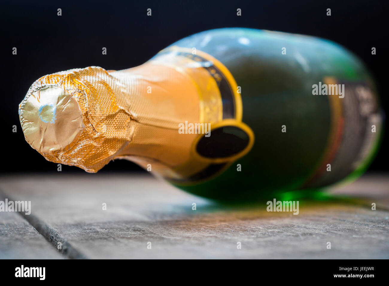 A bottle of champagne lying on the floor close up Stock Photo - Alamy