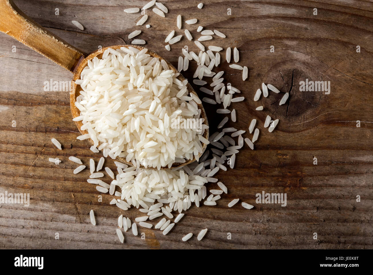 Wooden spoon filled with rice on rustic wooden background with copy ...