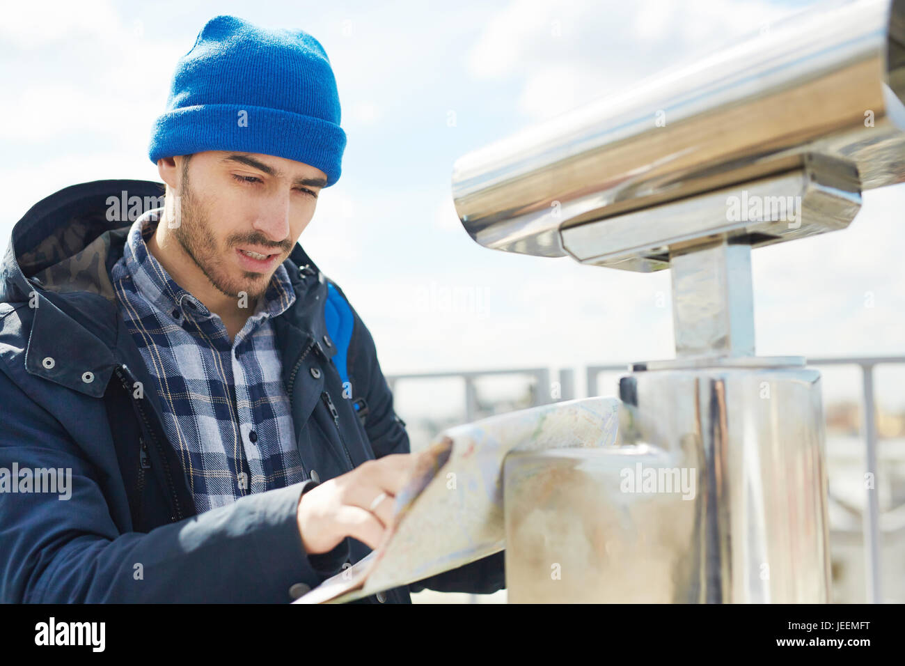 Young traveler looking at location map Stock Photo - Alamy