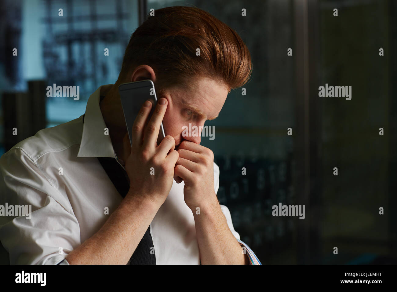 Serious man with cellphone making call home to say that he has much to ...