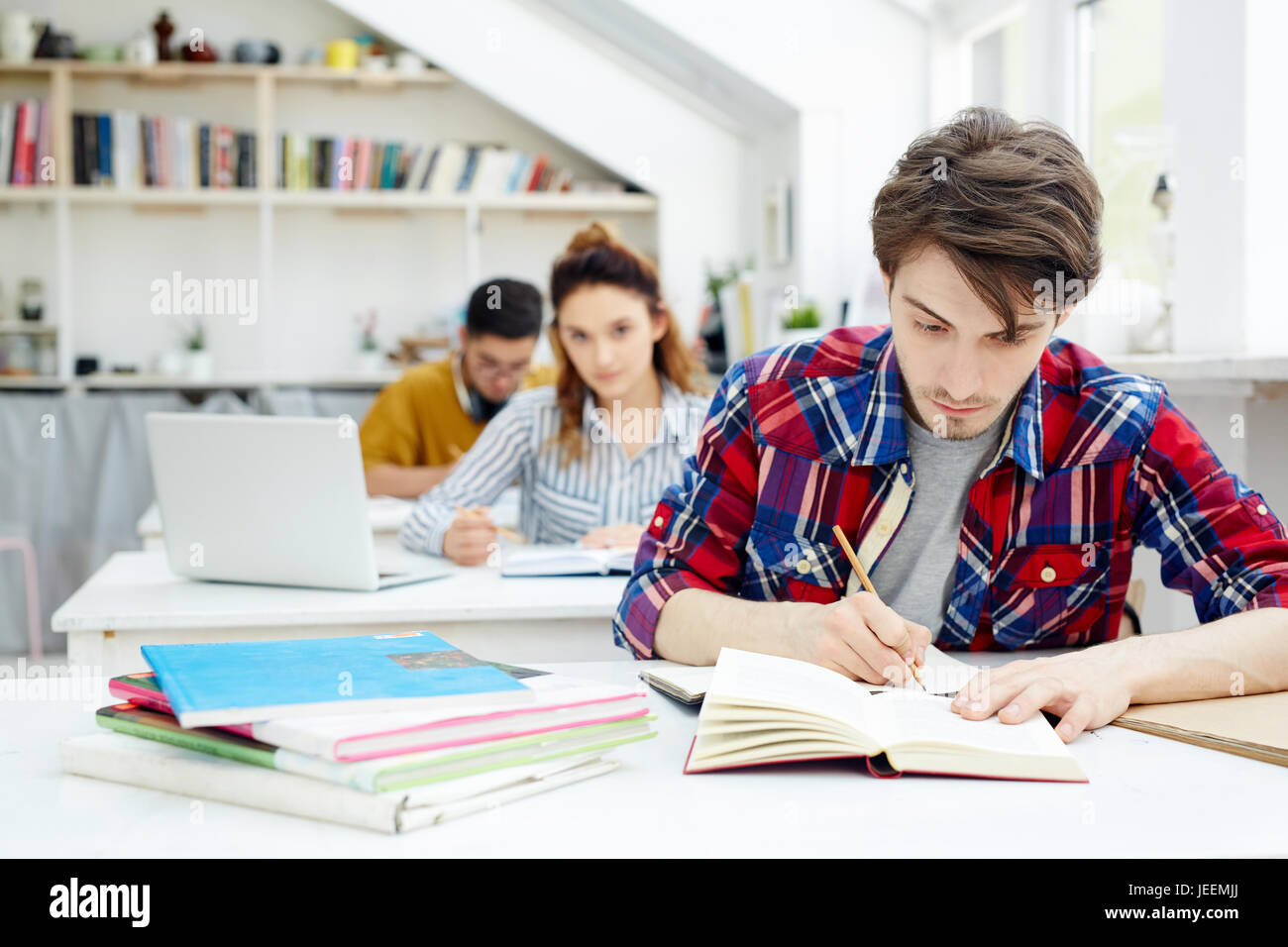 Clever student making notes at lesson Stock Photo - Alamy