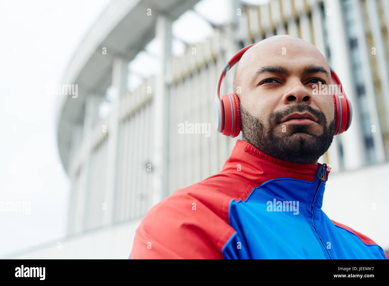 Calm guy in sportswear enjoying music in headphones Stock Photo - Alamy