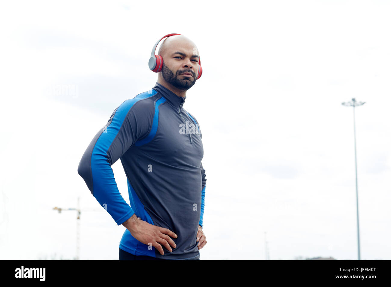 Active guy in headphones keeping his hands on hips Stock Photo - Alamy