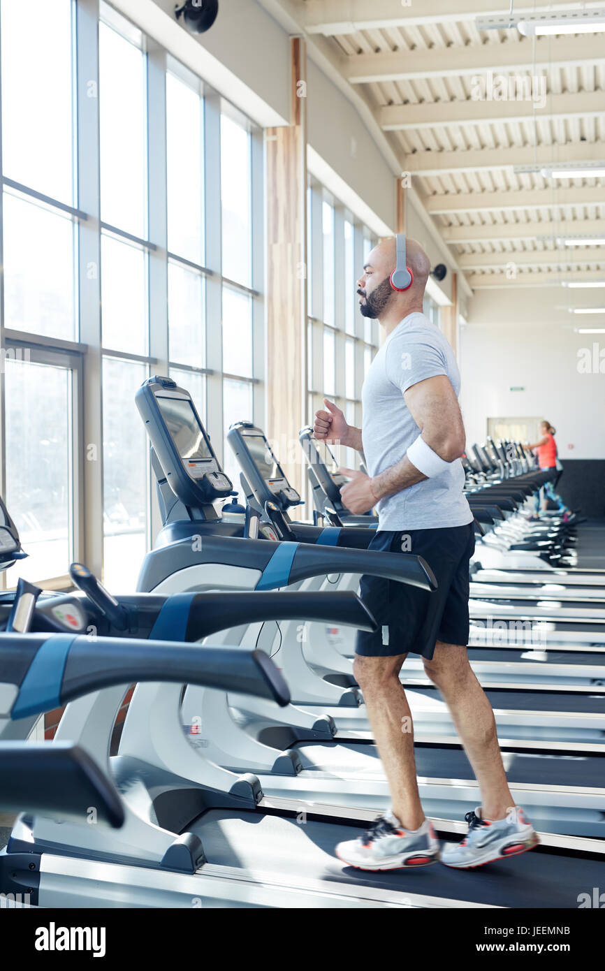 Sporty man walking on treadmill in gym Stock Photo - Alamy