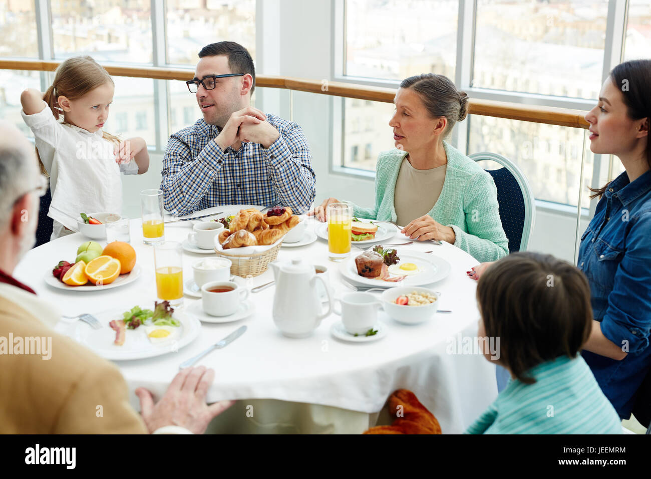 Big family having talk by breakfast in restaurant Stock Photo - Alamy
