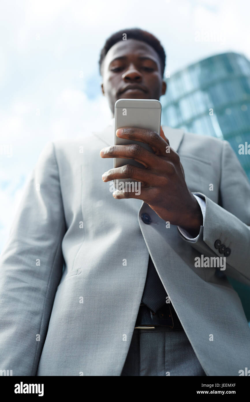 Man in suit texting outdoors Stock Photo - Alamy