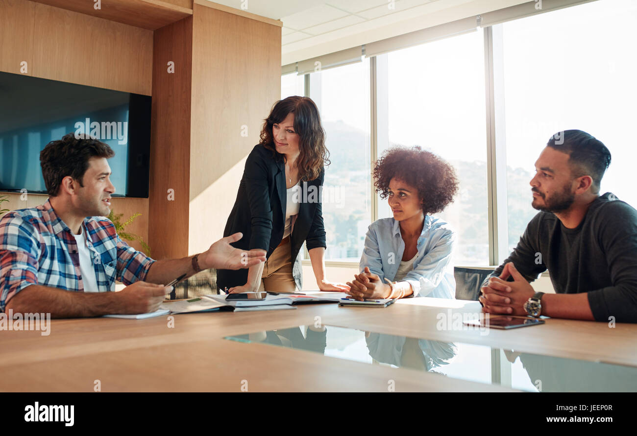 Four men sitting around table hi-res stock photography and images - Alamy