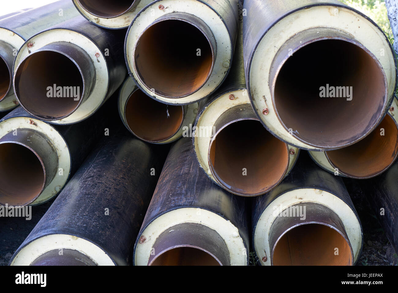 close up shot of a pile stack of big metal pipes tubes with heater ...
