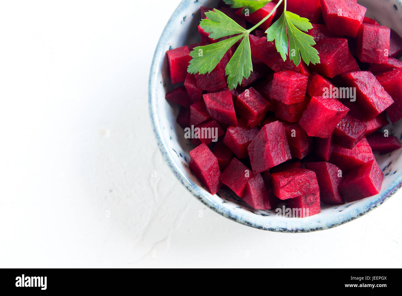 Beetroot (beet) chopped for salad in bowl over white background with ...