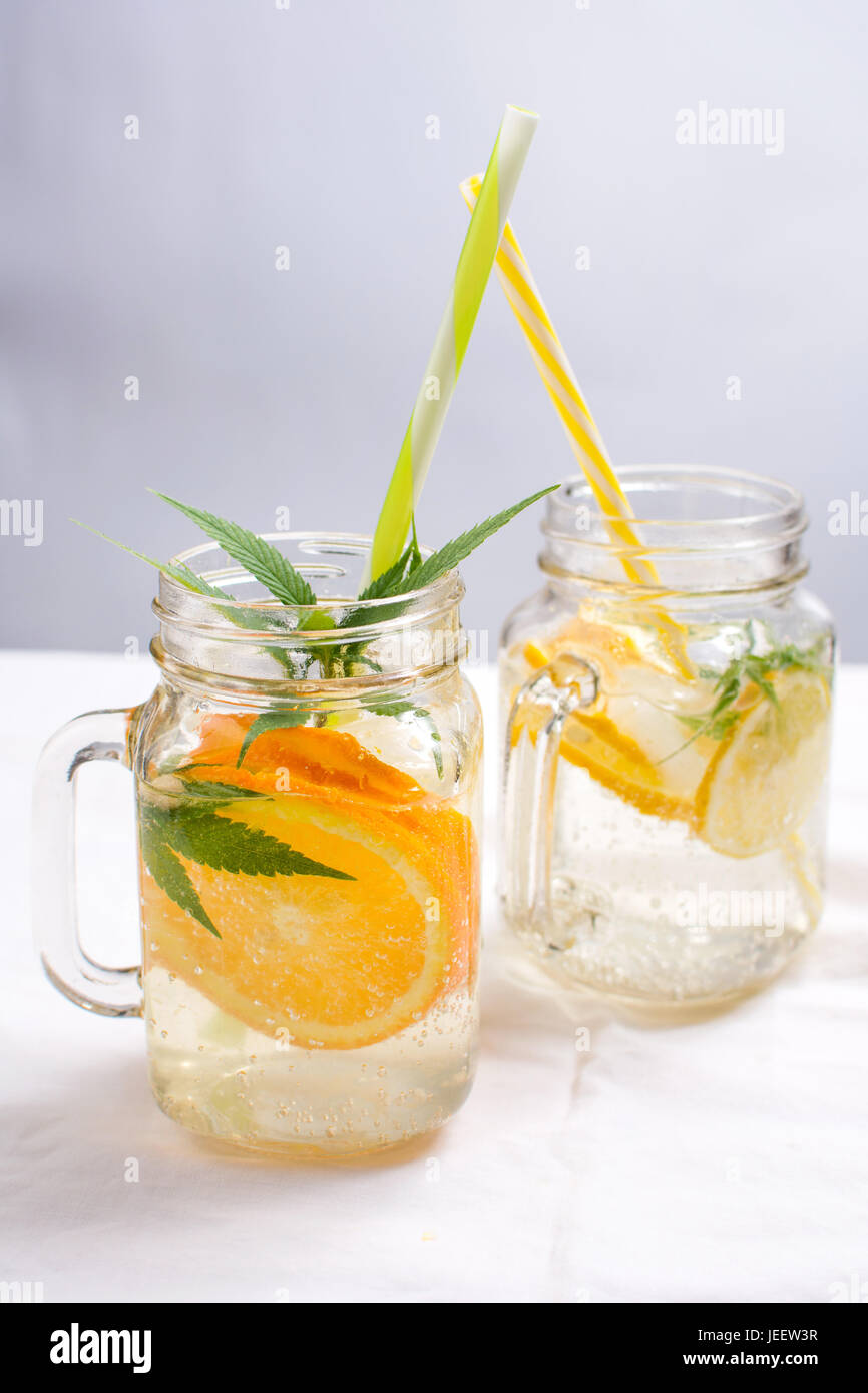 Water with orange, lemon and mint leaves in glass jars Stock Photo - Alamy