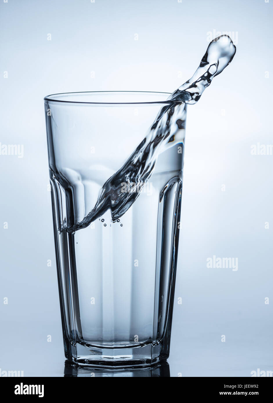 water splashing out of a glass with reflection Stock Photo - Alamy