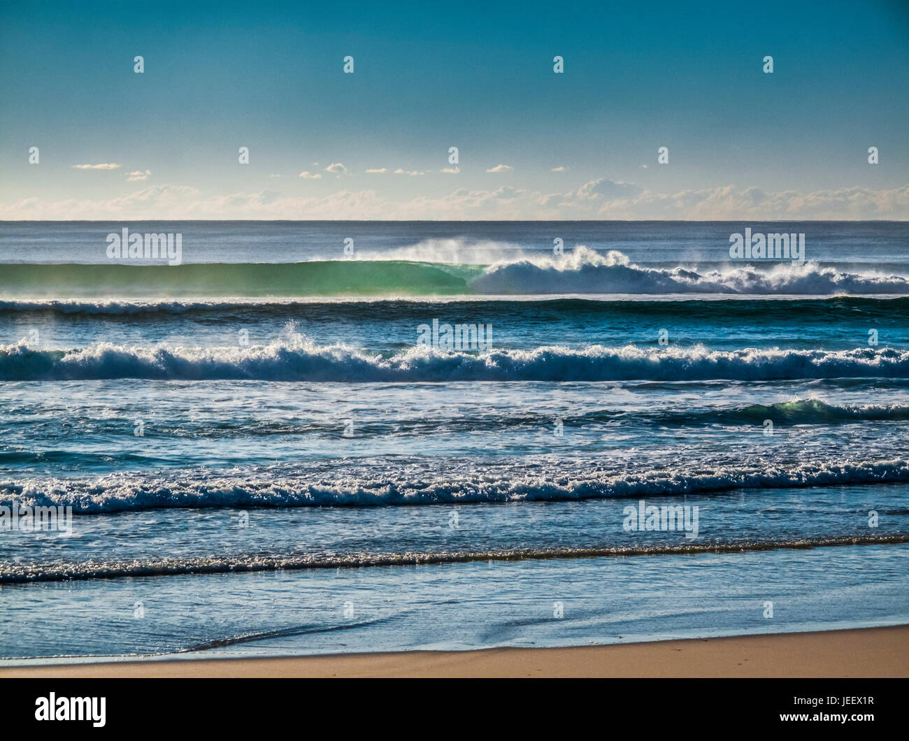 Series of breaking waves rolling into a beach Stock Photo - Alamy