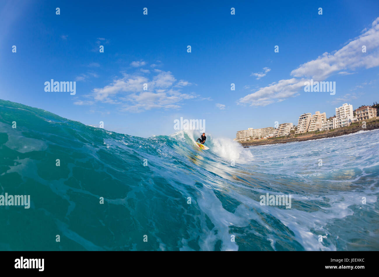 Surfer Surfing ocean wave along Ballito Bay coastline with holiday ...
