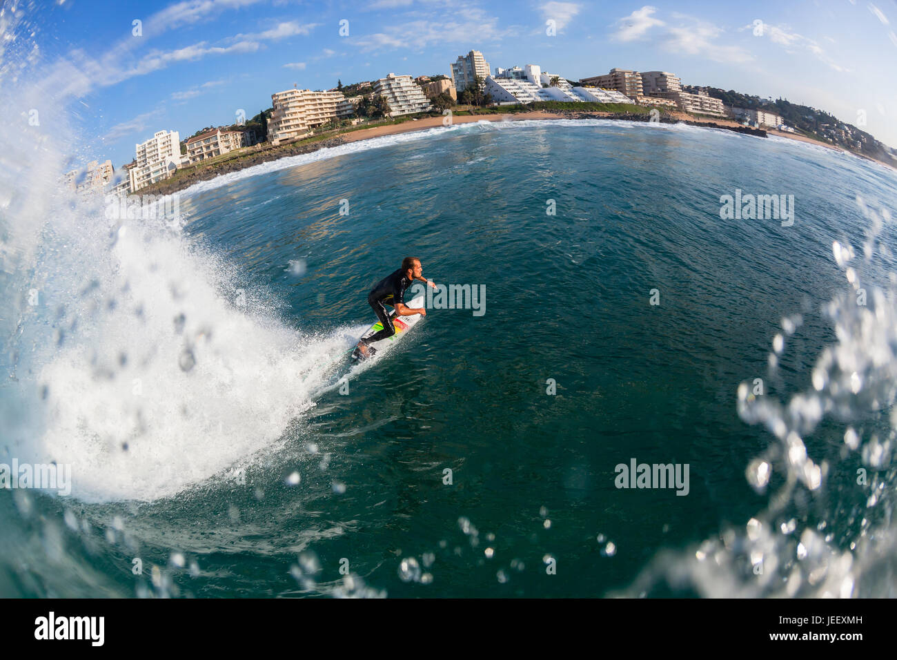 Surfer Surfing ocean wave along Ballito Bay coastline with holiday ...