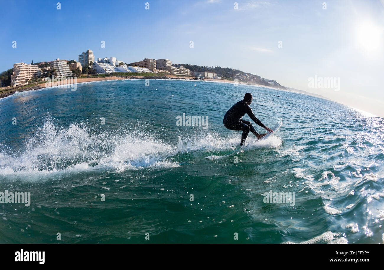 Surfer Surfing ocean wave along Ballito Bay coastline with holiday ...