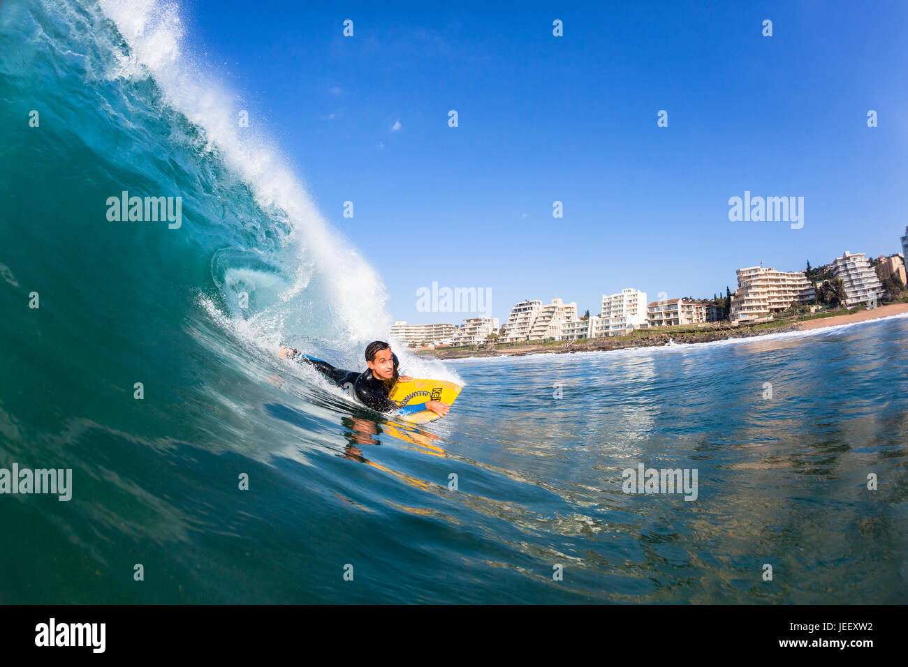 Surfer Surfing ocean wave along Ballito Bay coastline with holiday ...