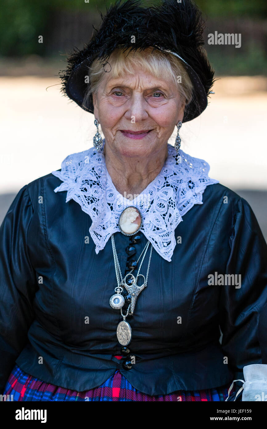 Portrait of senior lady, 60, facing, smiling. Dressed in Victorian ...