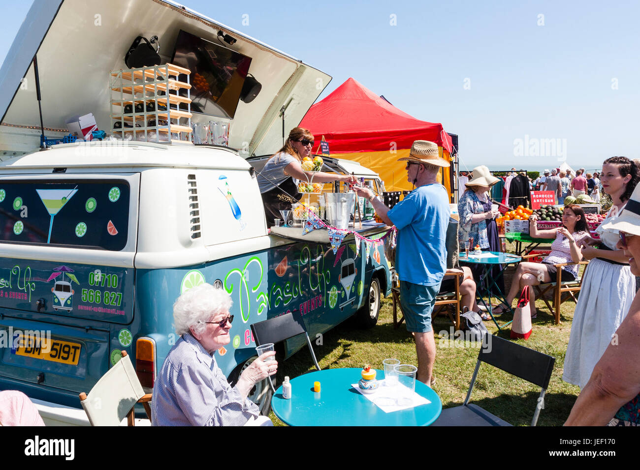 VW camper van turned into a mobile bar. Roof hinged up with woman ...
