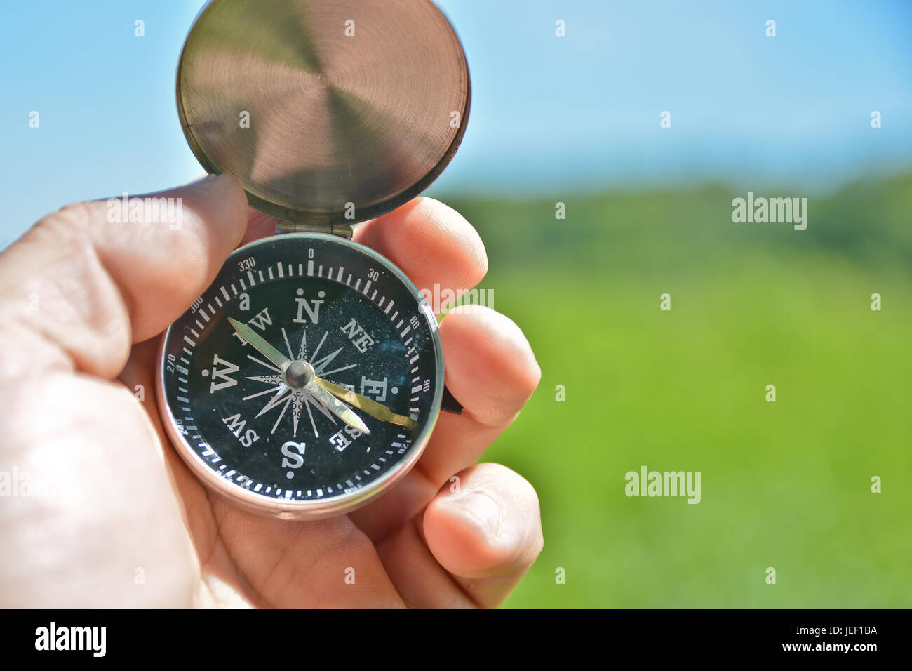 The hand holds the compass. Orientation on the terrain during a walk ...