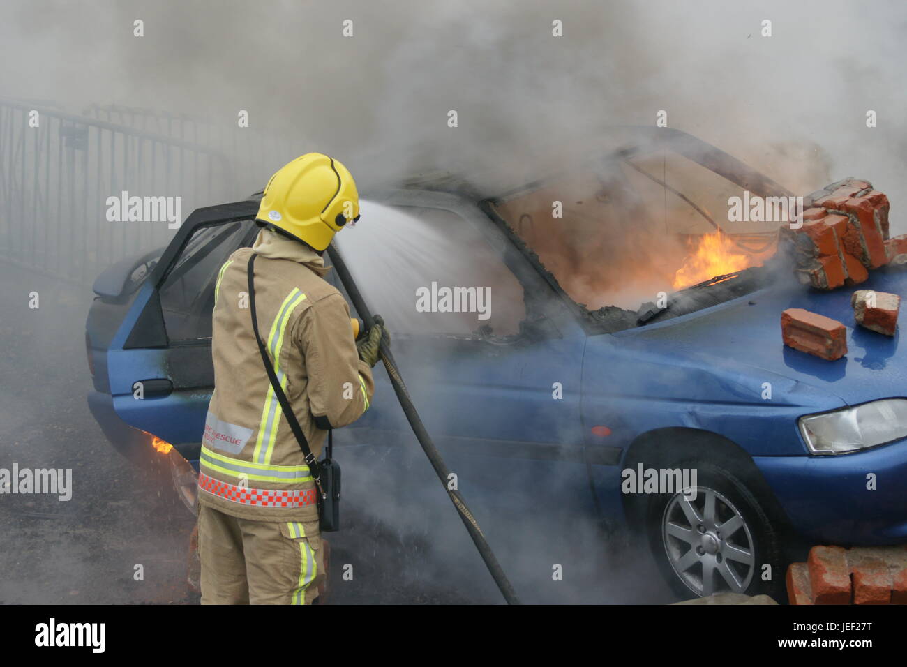 fire fighter fighting car fire Stock Photo - Alamy