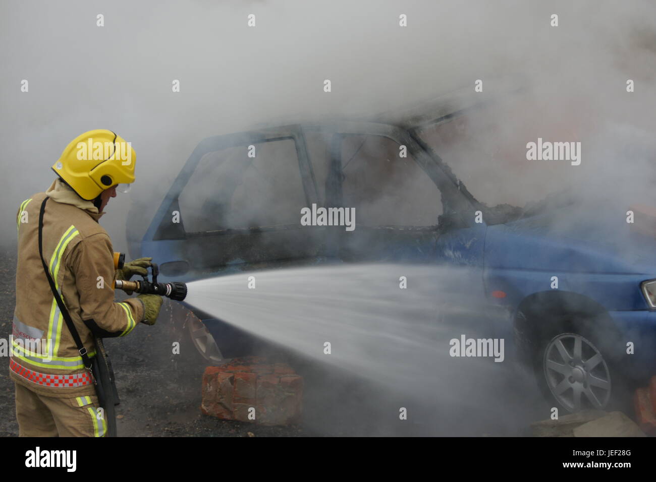 fire fighter fighting car fire Stock Photo - Alamy